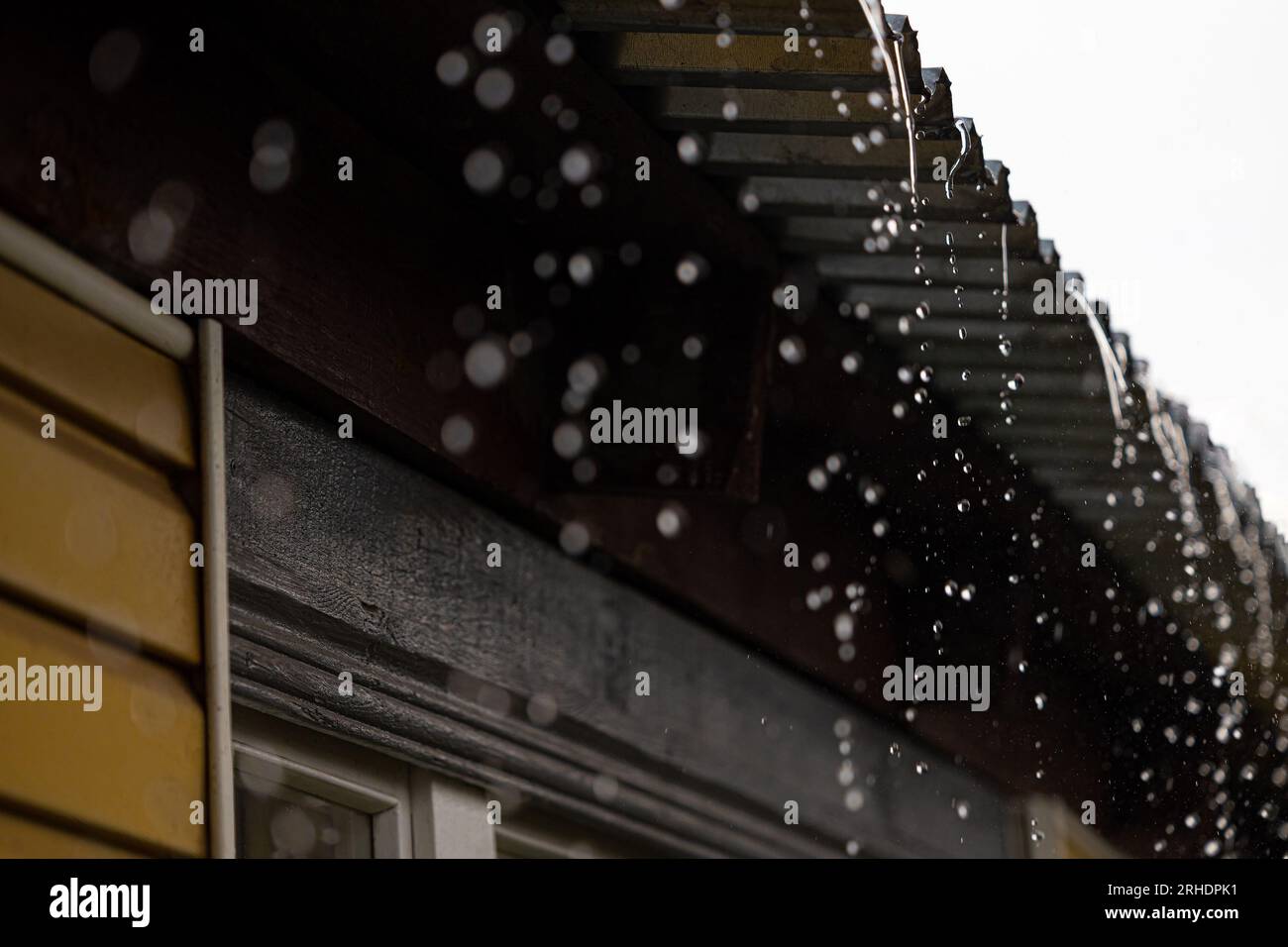 rainwater flows down from the roof of the house during the rain ...