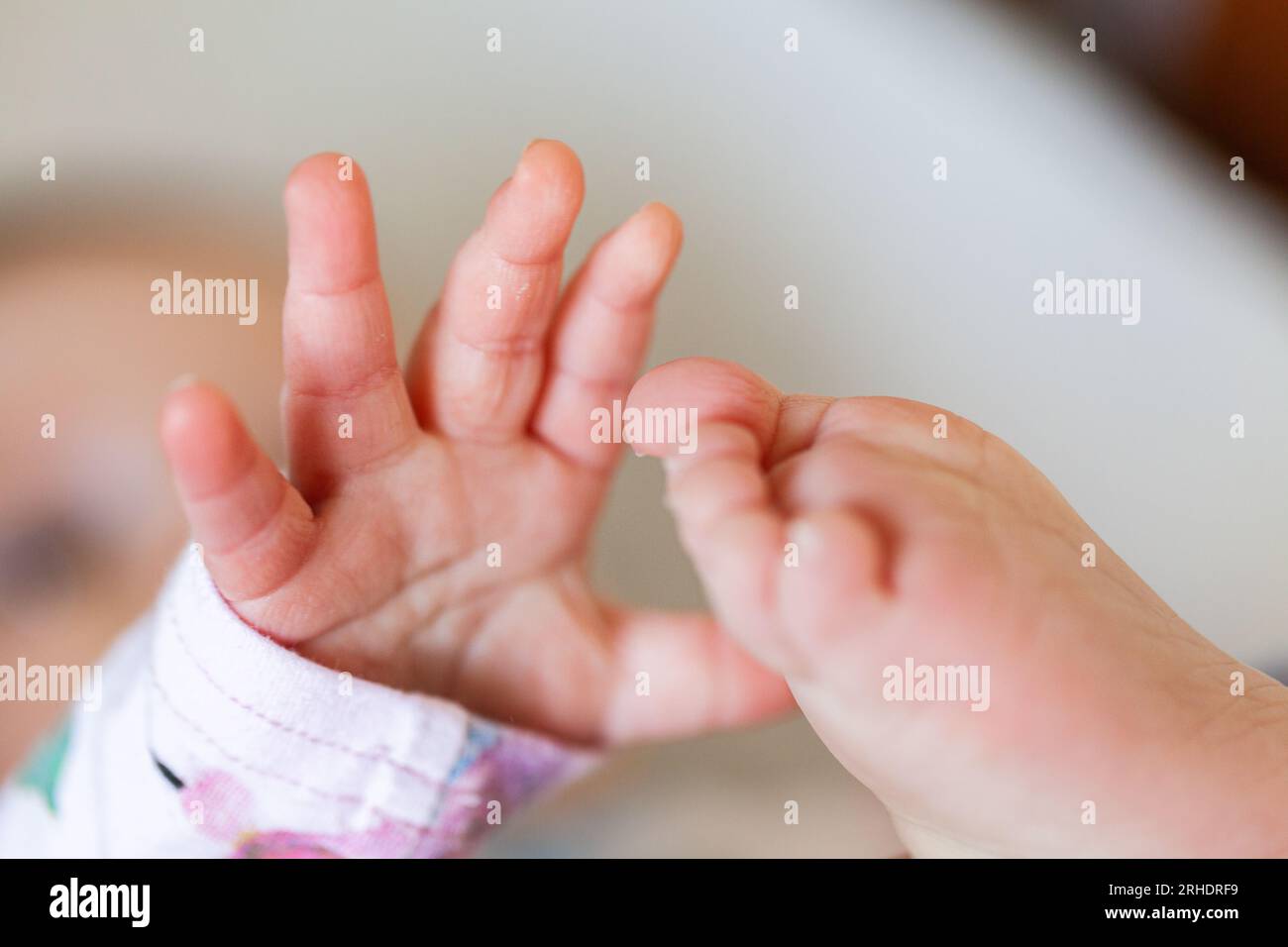 Close up detail of baby fingers grabbing at toes Stock Photo - Alamy
