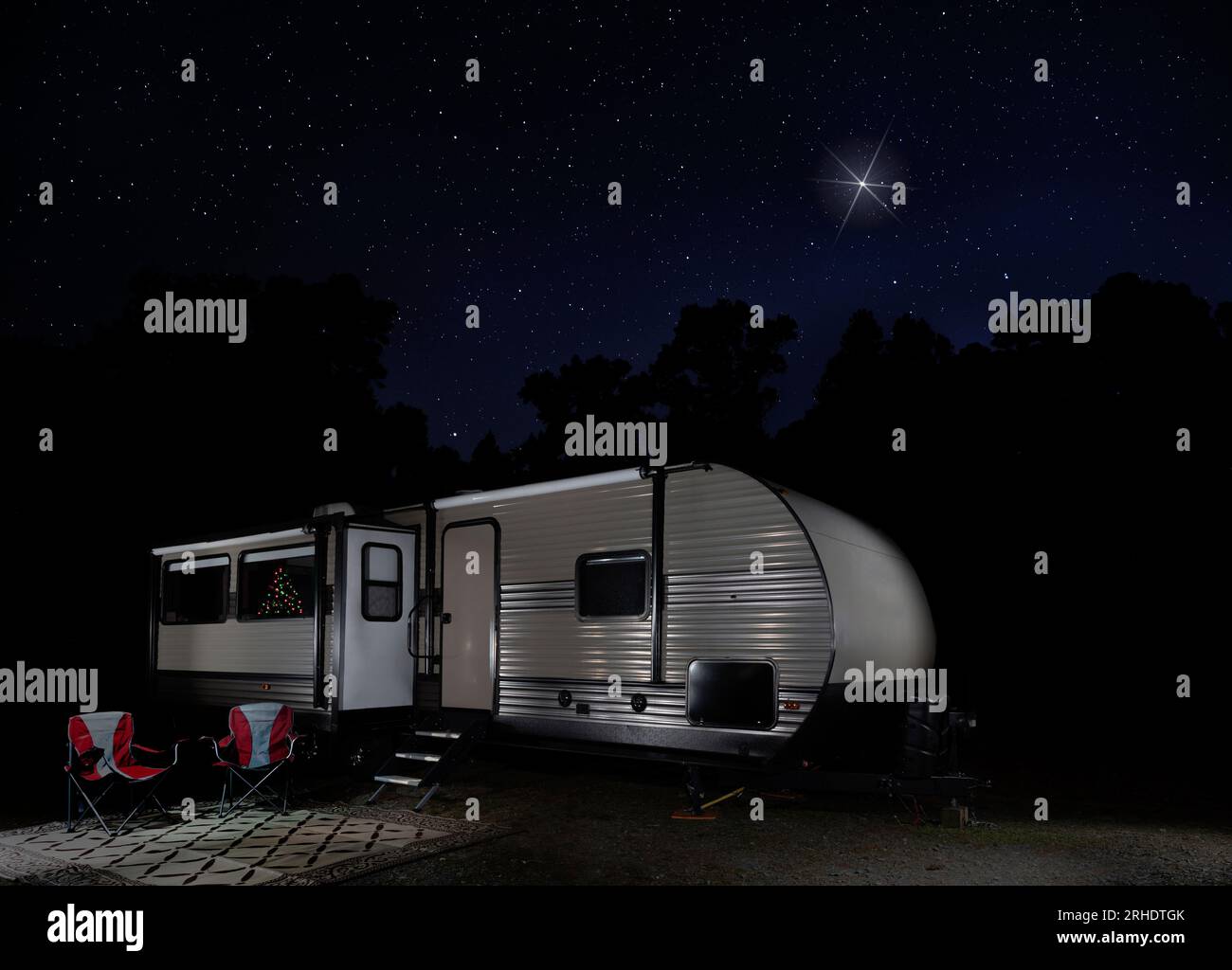 RV with a Christmas tree lit inside and the Christmas star shining ...