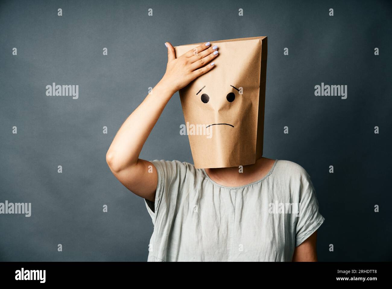 Woman with hand on head and upset smile on the paper bag on head. Bad ...