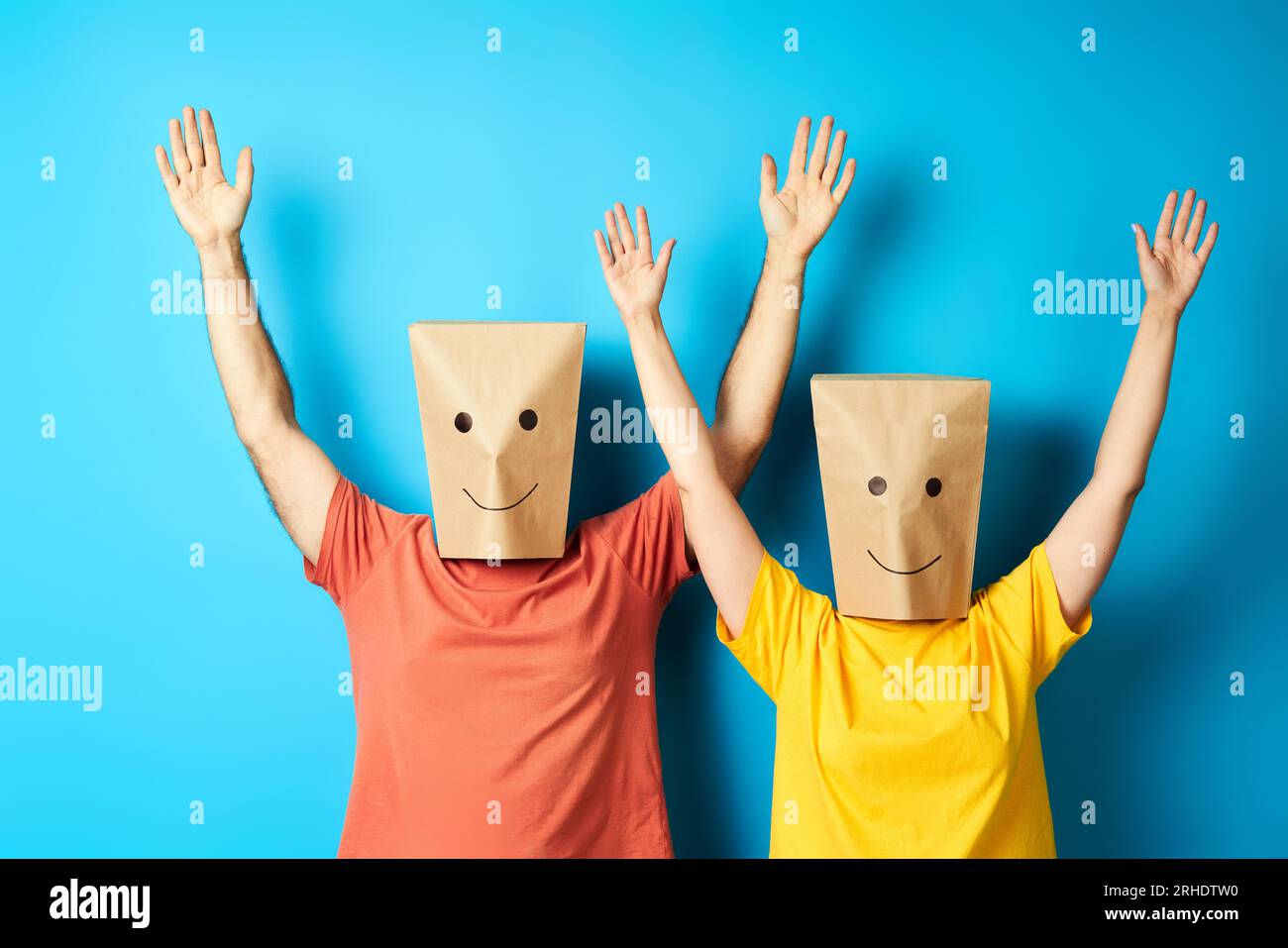 Happy smiling couple with bags over heads celebrating success with ...
