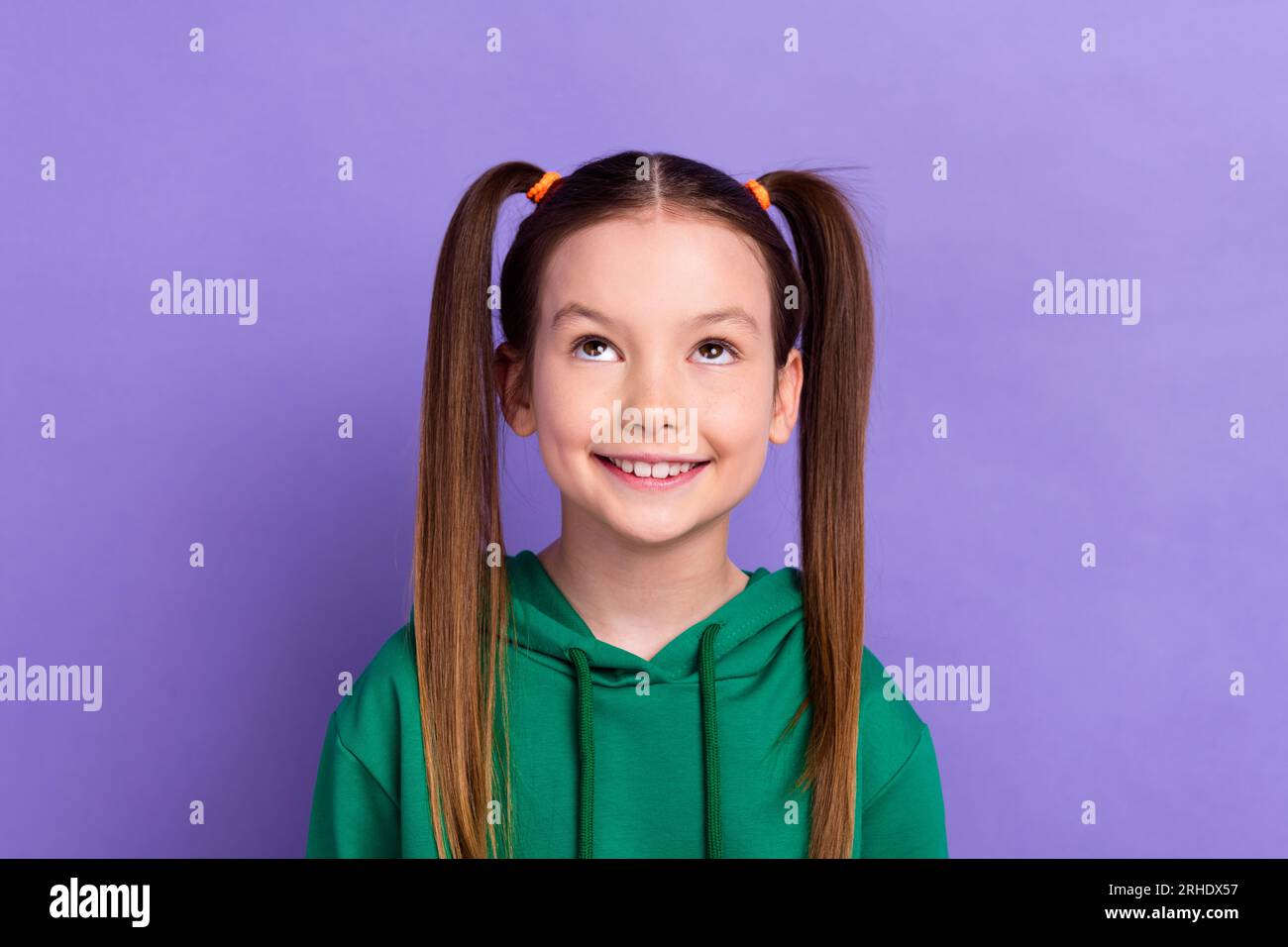 Photo of funny little pupil age girl wearing green hoody looking up ...