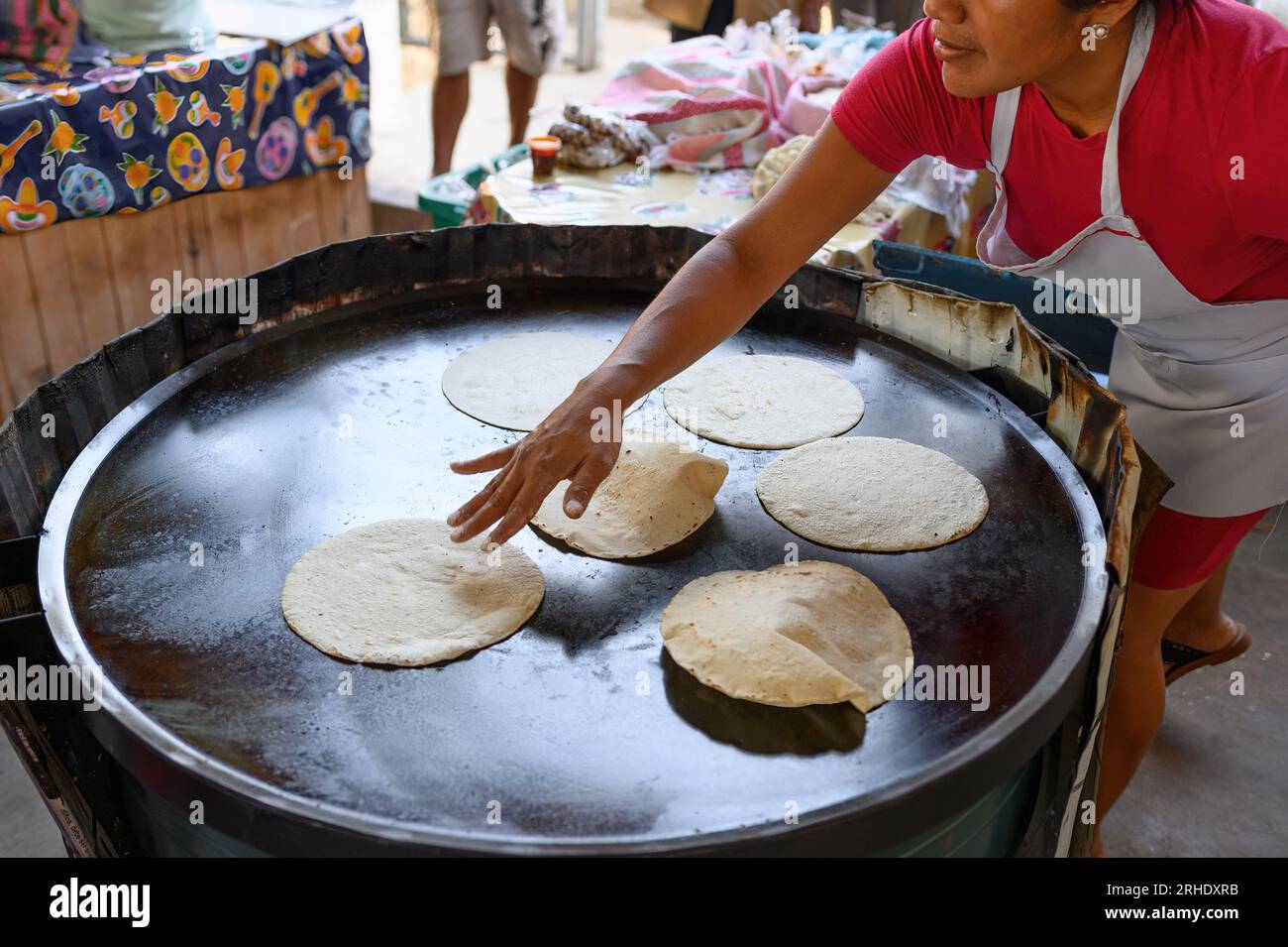 From above of crop unrecognizable Mexican female cook putting dough on ...