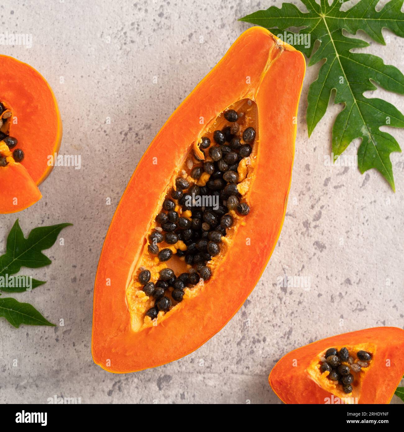 Cut Papaya over gray table background for tropical fruit design concept ...