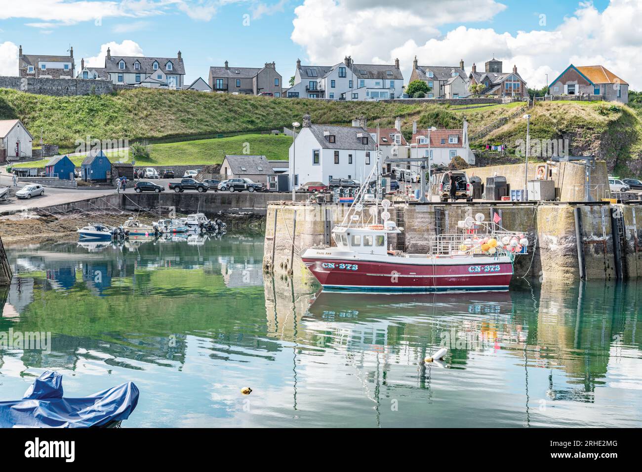 Fishing Boat docked in St Abbs Harbour with the village behind, St Abbs ...