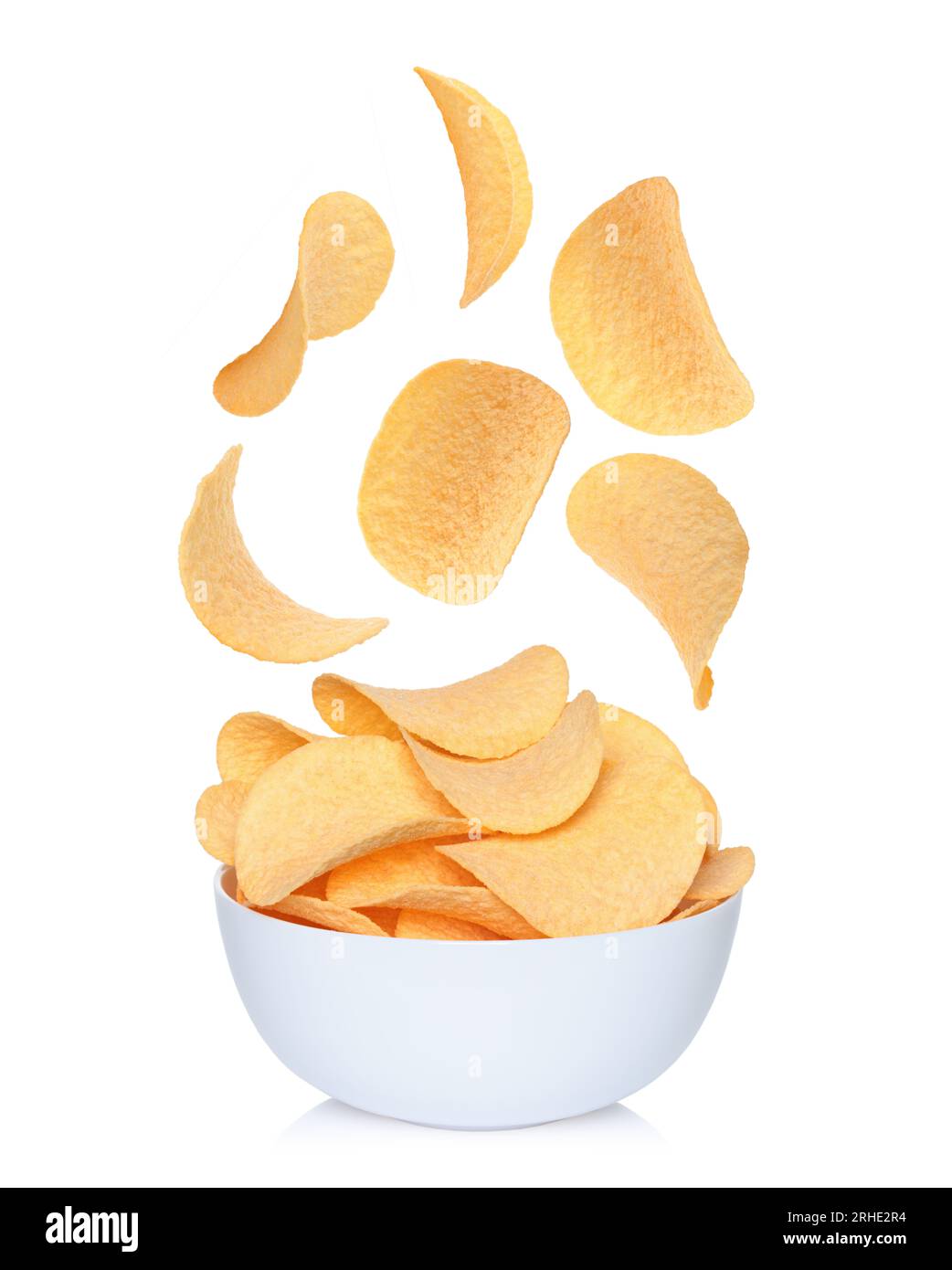Levitating potato chips, falling to white bowl on white background ...