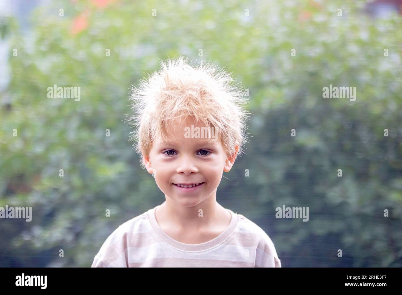 Cute little boy with static electricy hair, having his funny portrait ...