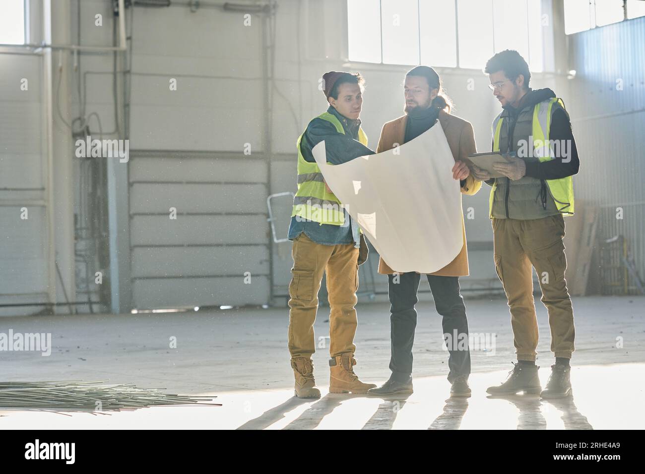 One of two engineers explaining point of sketch to contractor and ...