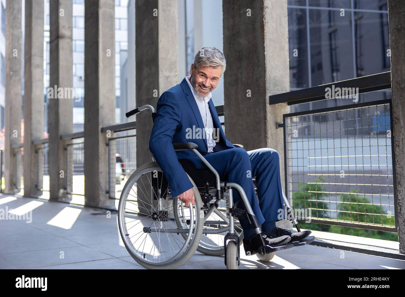 Gray haired disabled man wearing official style suit in wheelchair city ...