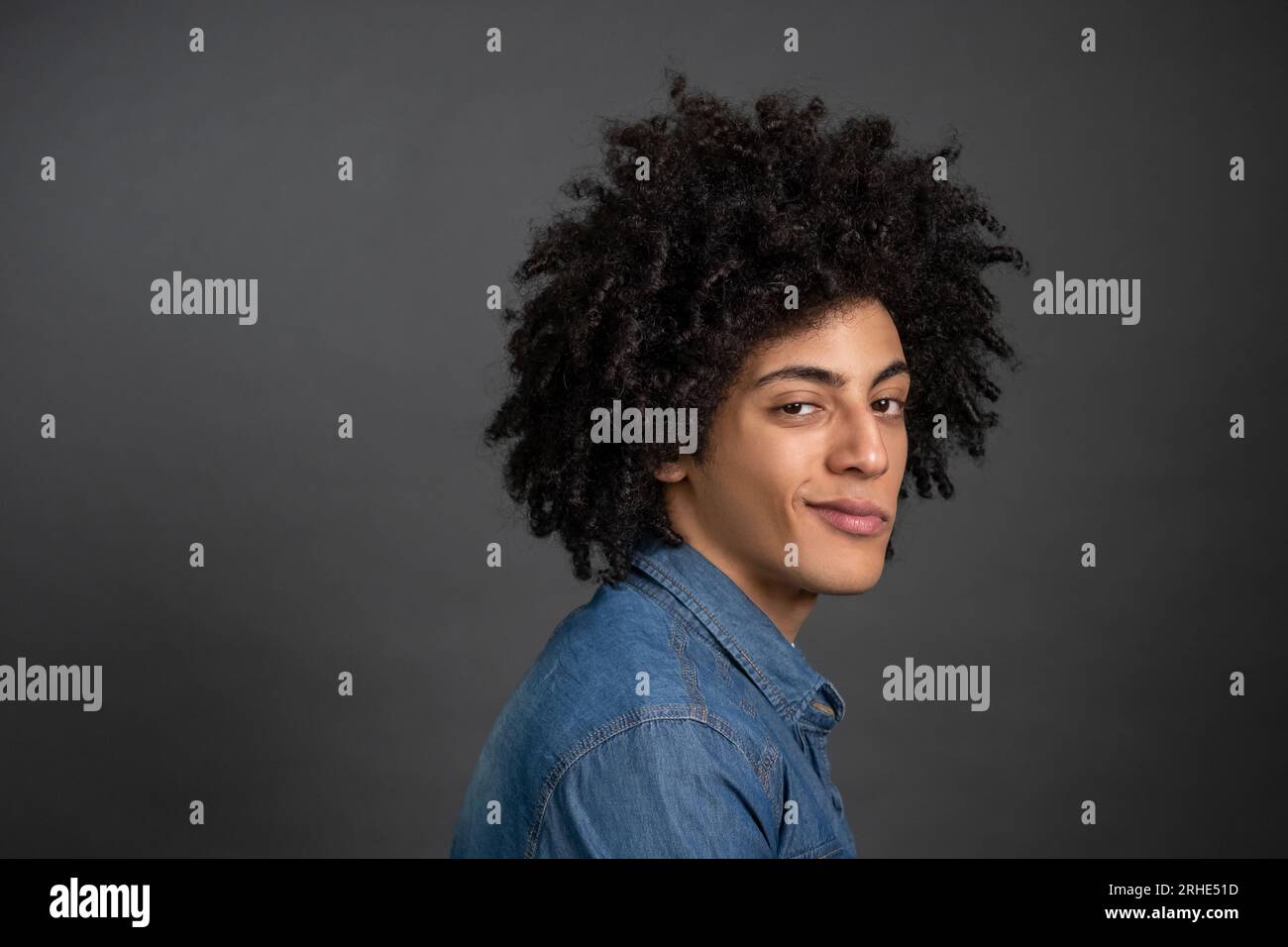 Curly-haired young guy smirking and looking foxy Stock Photo - Alamy