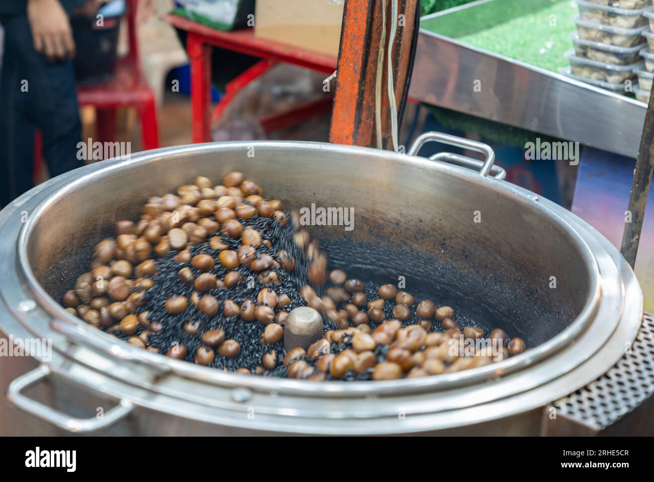 Frying chestnuts in oven roasted at street food market Stock Photo - Alamy