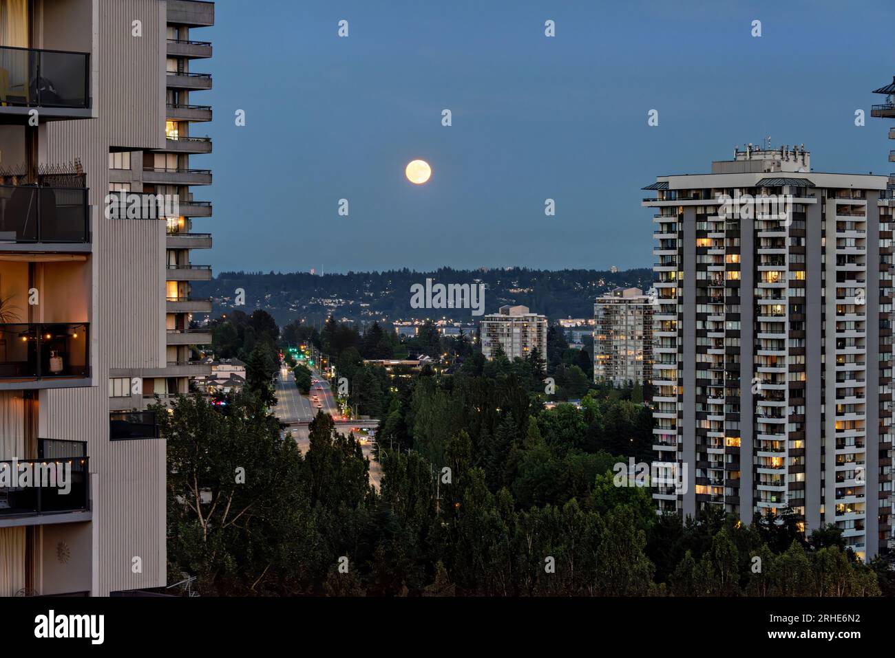 Night city view with full yellow moon raising over Stock Photo - Alamy