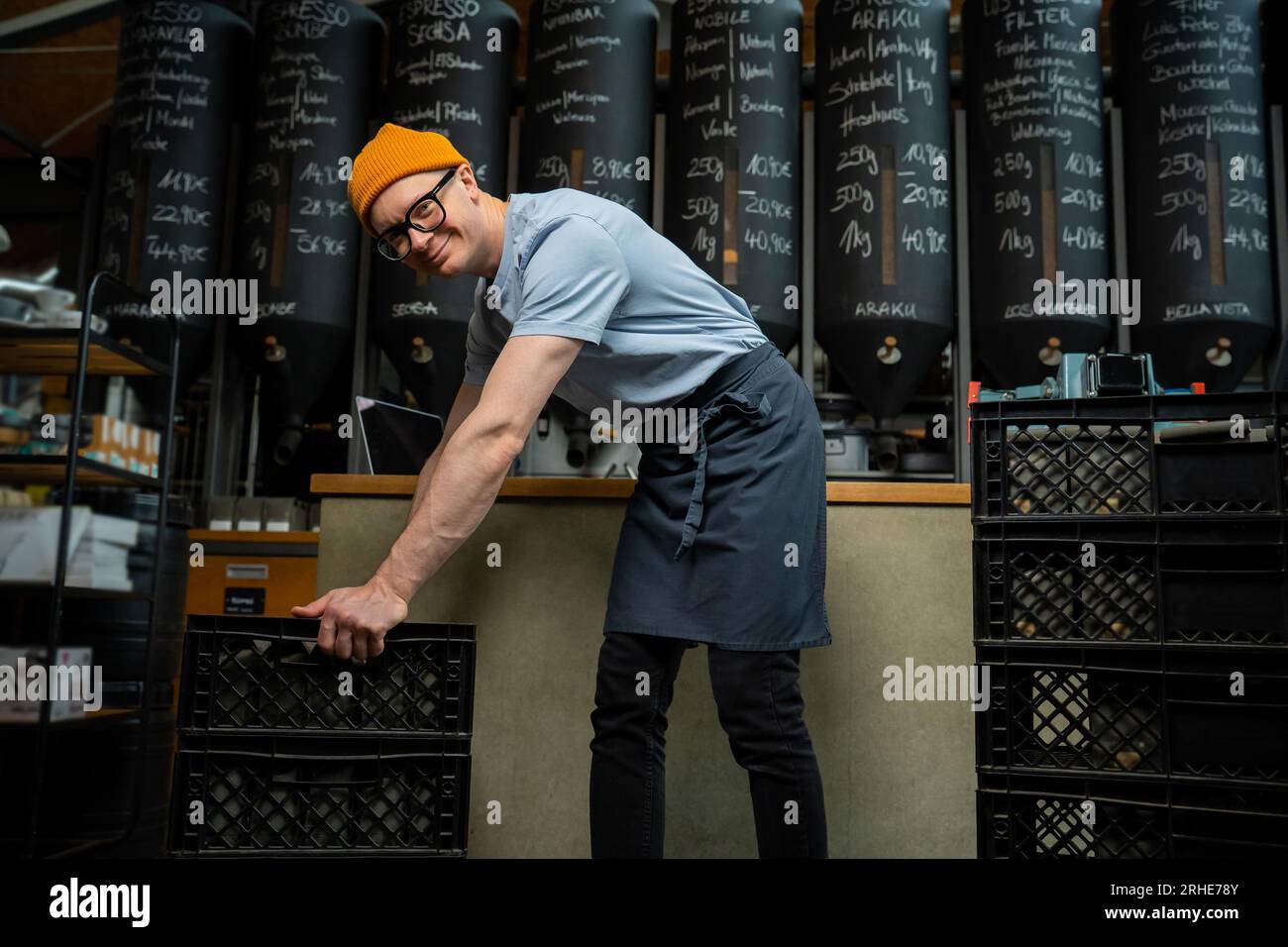 Bartender barista uploads paper coffee packages in boxes on roasting ...