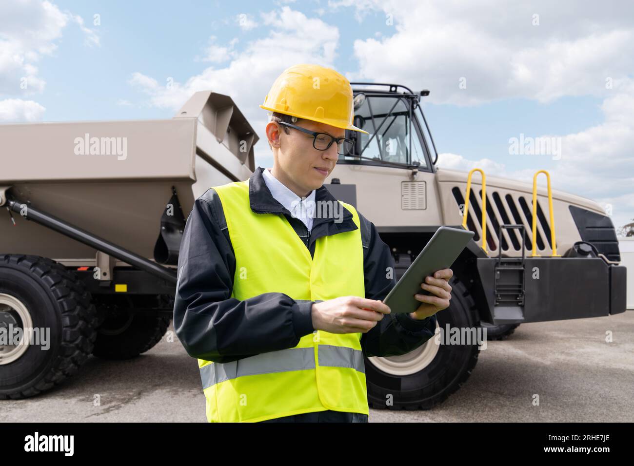 Man worker with tablet computer stands next to mining truck Stock Photo ...