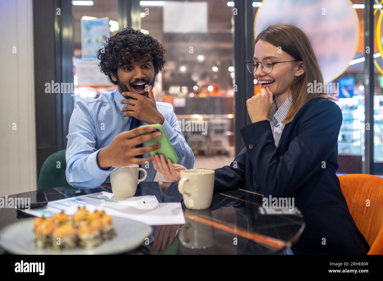 Two colleagues discussing project details at lunch Stock Photo - Alamy