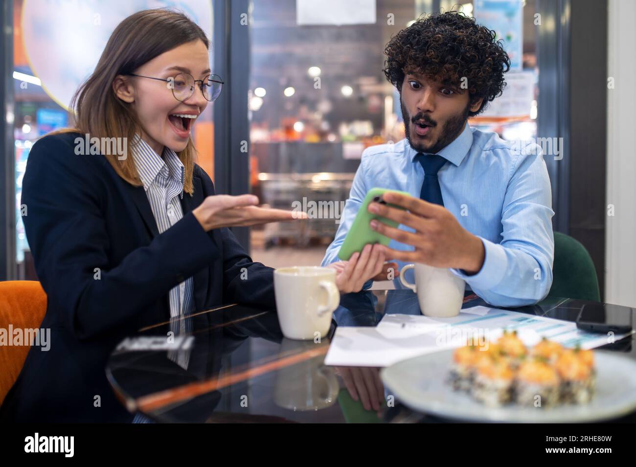 Two colleagues discussing project details at lunch Stock Photo - Alamy