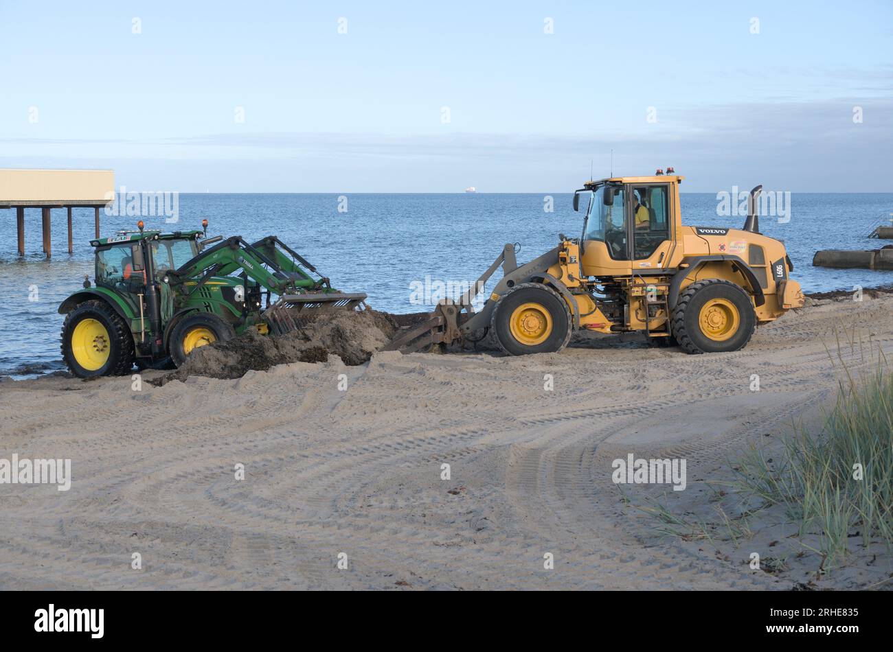 Tractors cleaning the beach from seaweed after the storm Stock Photo ...