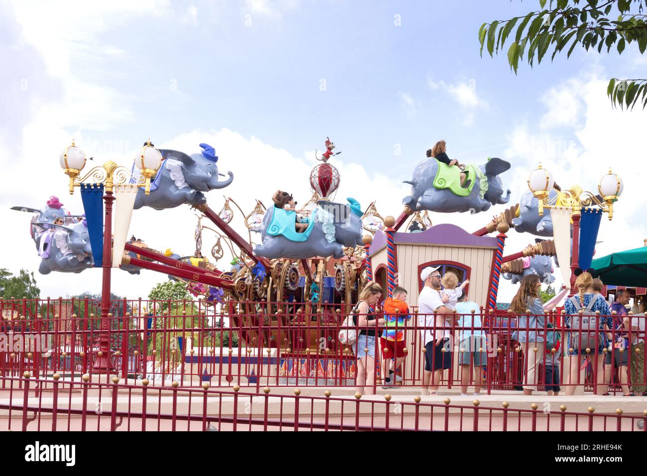 Disneyland Paris ride - people on the Dumbo ride and queuing in the ...
