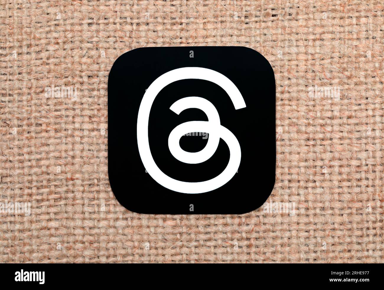 Threads mobile app icon on a sackcloth textile background close-up ...