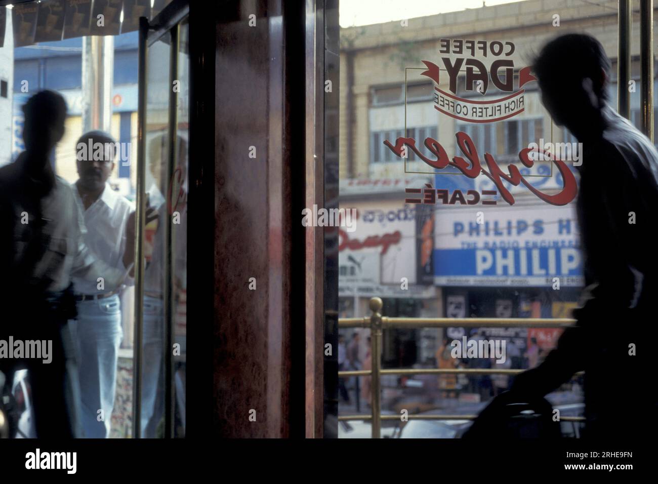 a Cyber cafe on a Road with Shops and Traffic in the city of Bangalore ...