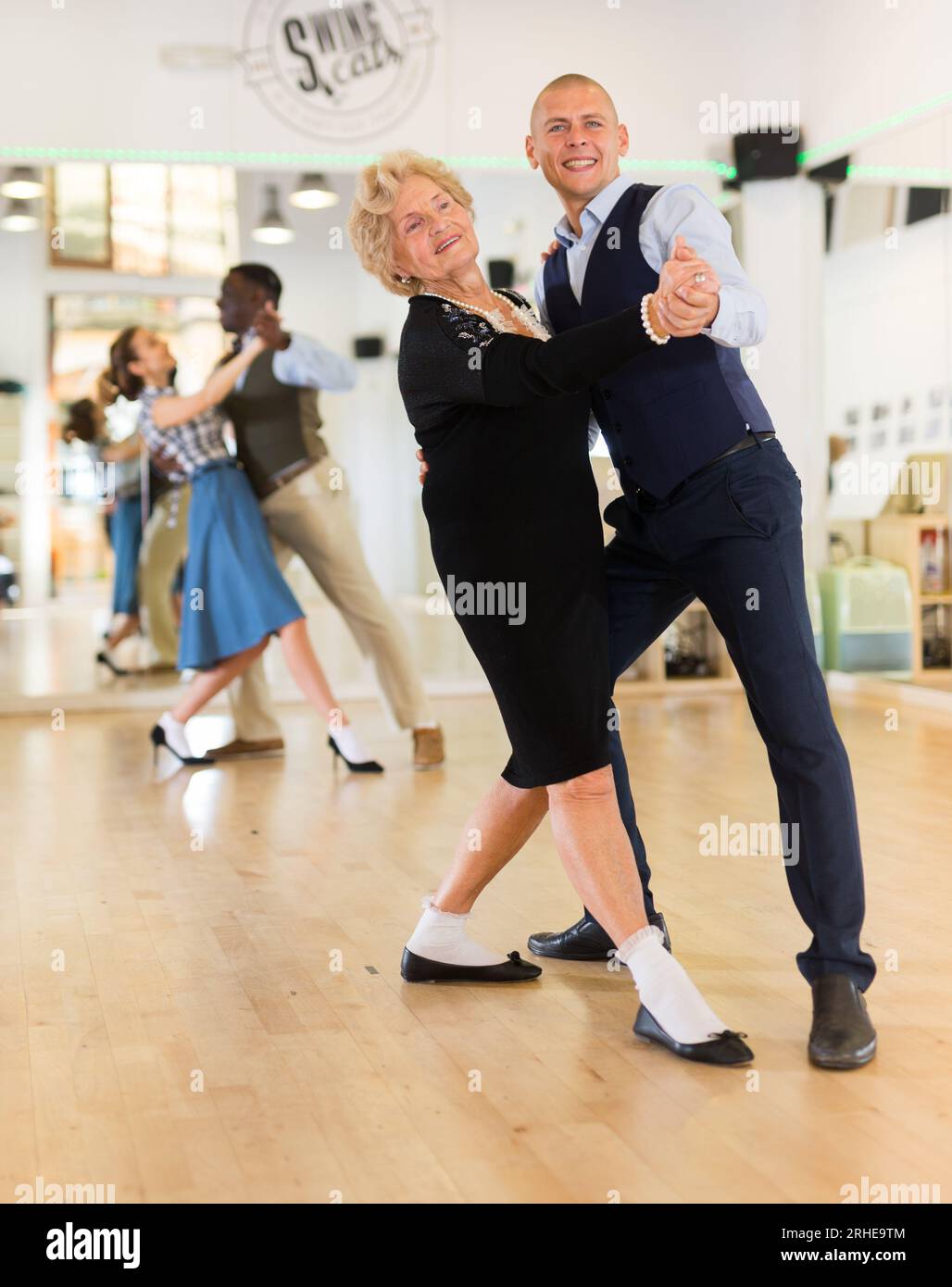 Elderly woman learning ballroom dancing movements in pair Stock Photo ...