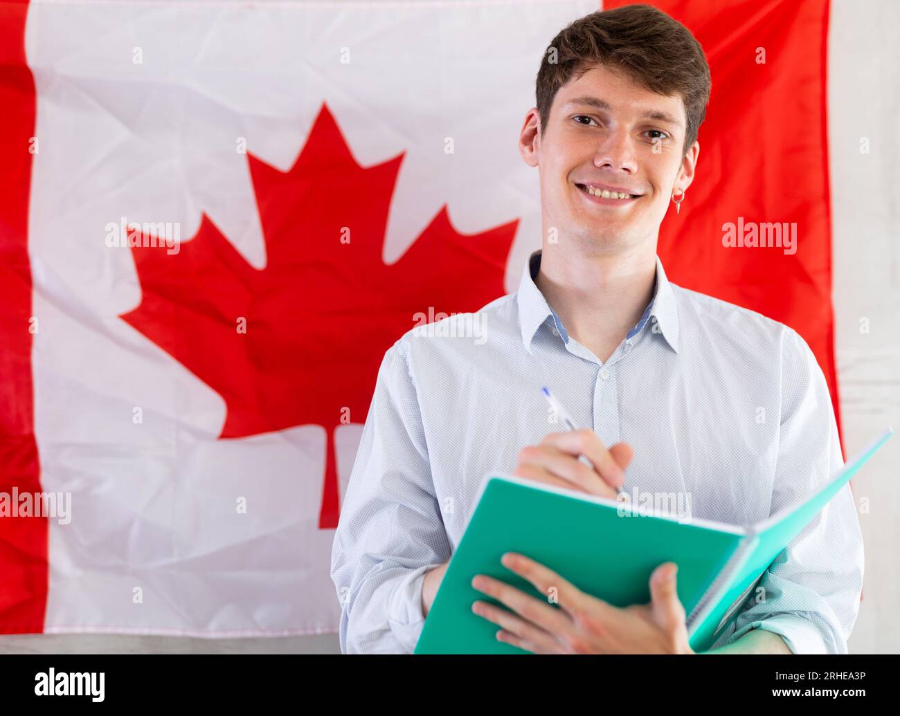 Young guy makes notes against background of Canada flag Stock Photo - Alamy