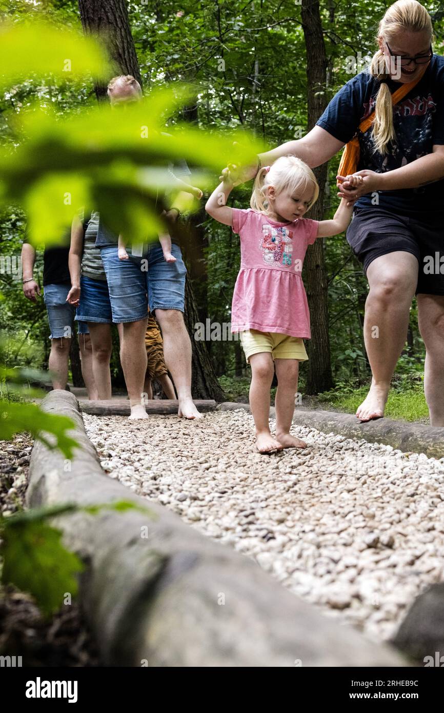 BRUNSSUM - Visitors to the barefoot park walk over various obstacles ...