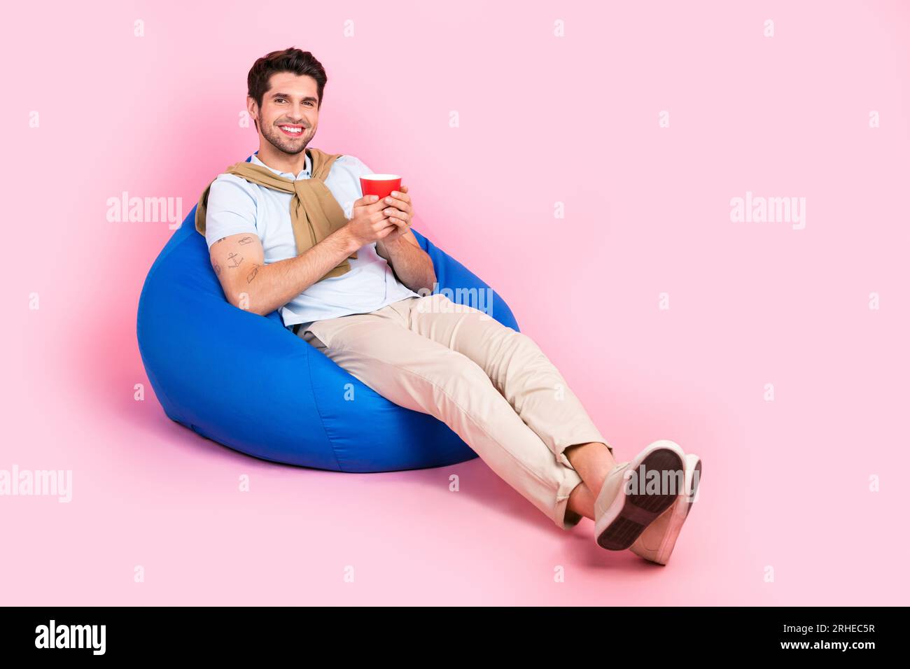 Full body size photo of relaxed young man lying bean bag drink sweet ...