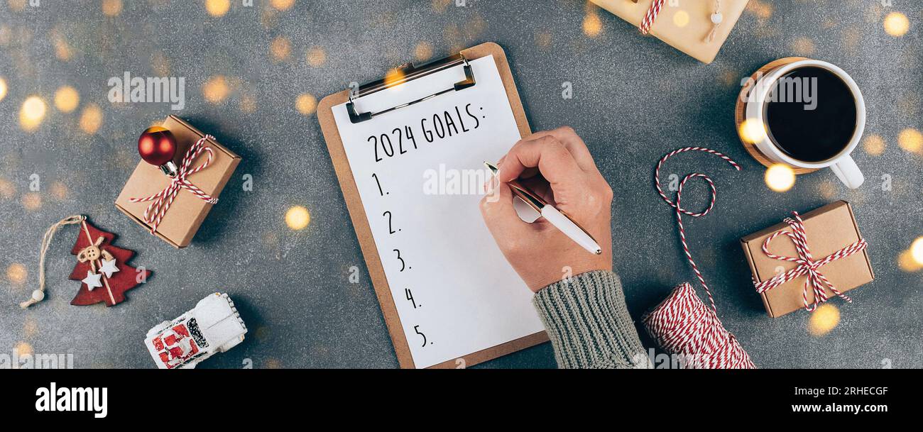 Happy New Year 2024. Woman's hand writing 2024 Goals in notebook ...