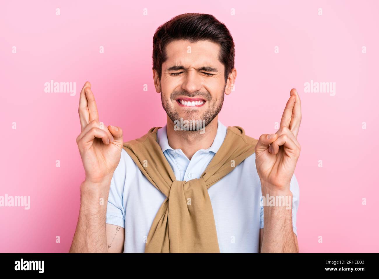 Portrait of young guy hipster expensive clothes crossed fingers bite ...