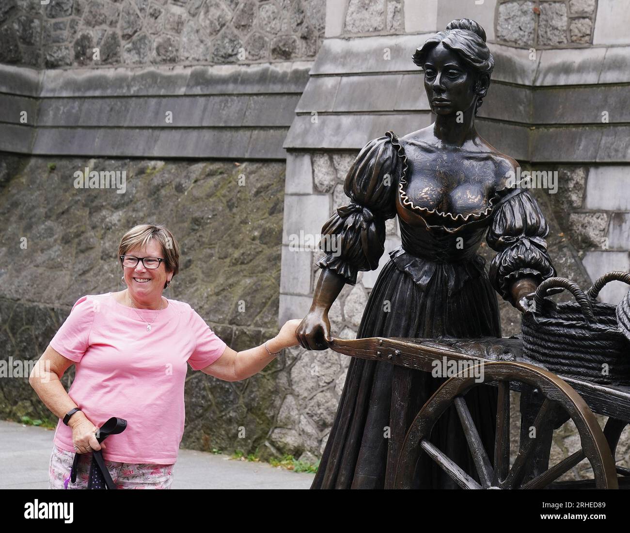 A person poses for a photograph with the iconic Molly Malone statue in Dublin's city centre ...