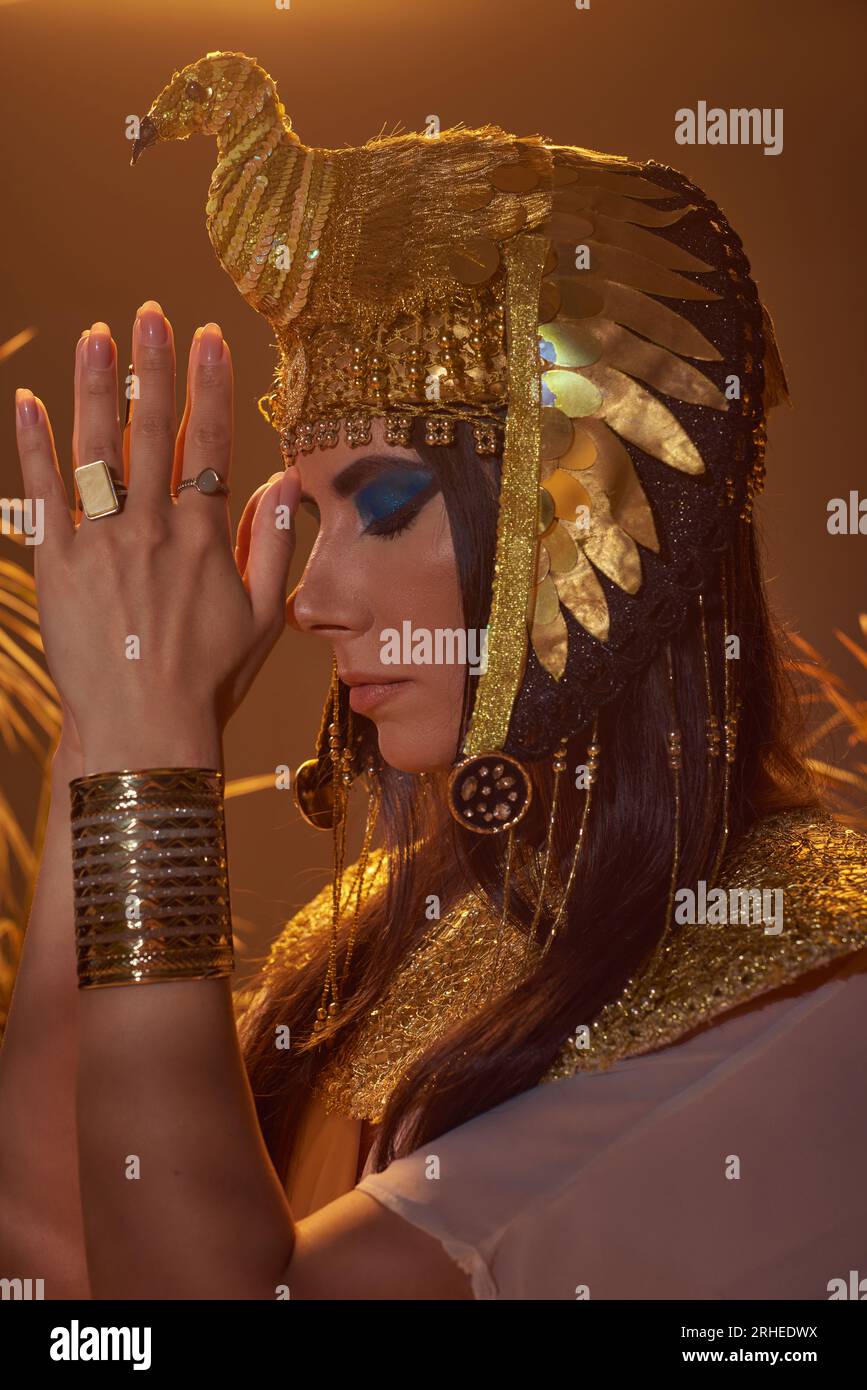 Woman in egyptian costume doing praying hands gesture near blurred ...