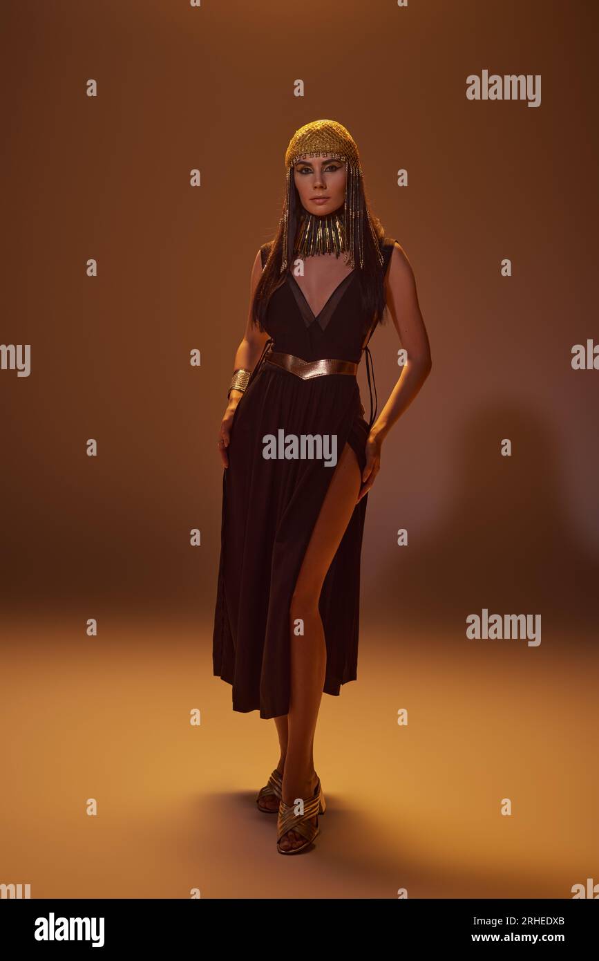 Full length of elegant woman in egyptian look and headdress standing ...