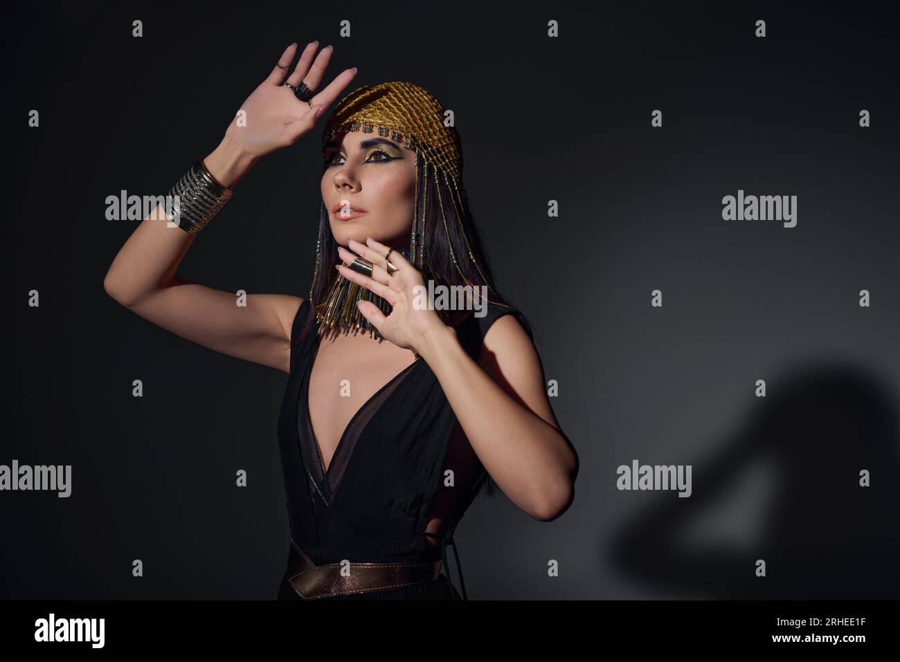 Beautiful woman in egyptian dress and necklace posing on black ...