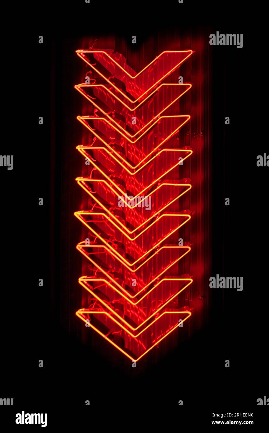 Set of red arrows neon light pointing down Stock Photo - Alamy