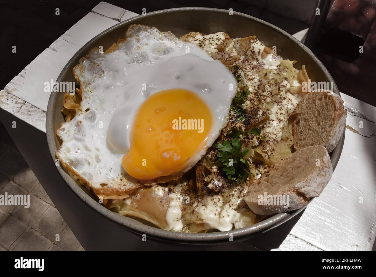 typical mexican food, chilaquiles with fried egg and bread on top ...