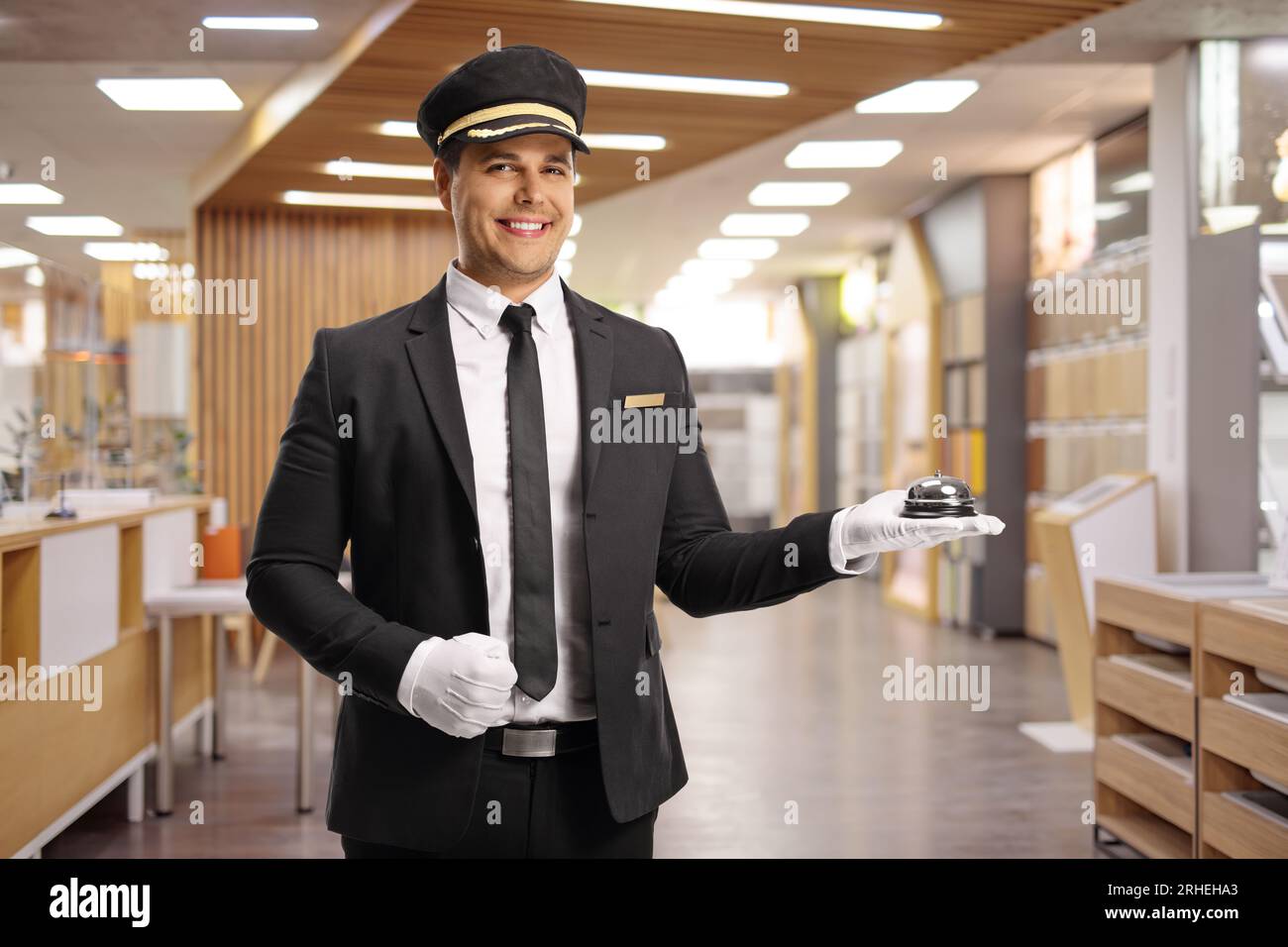 Bellboy holding a reception bell at a boutique hotel Stock Photo - Alamy