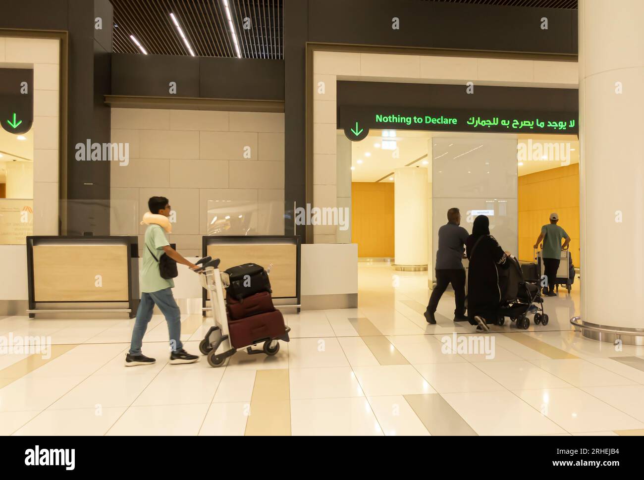 Bahrain airport customs sign and entrance. Passengers with luggage ...