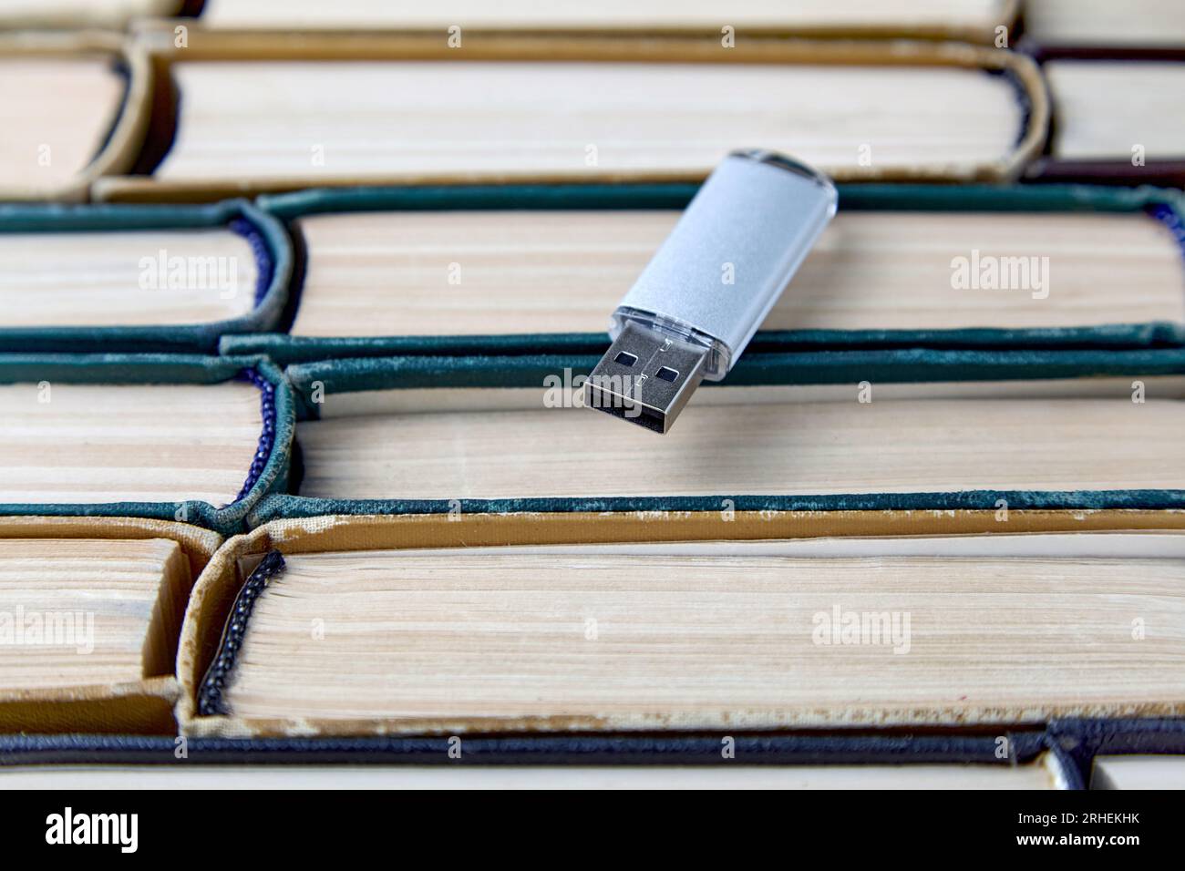 USB flash card on the background of a large stack of old shabby books ...