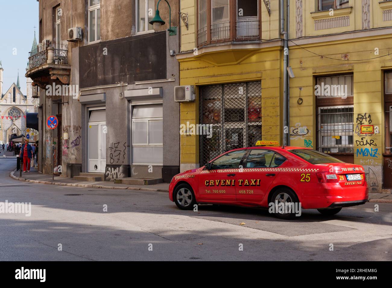 Red Taxi in a historic street with yellow facade and the Sacred Heart ...