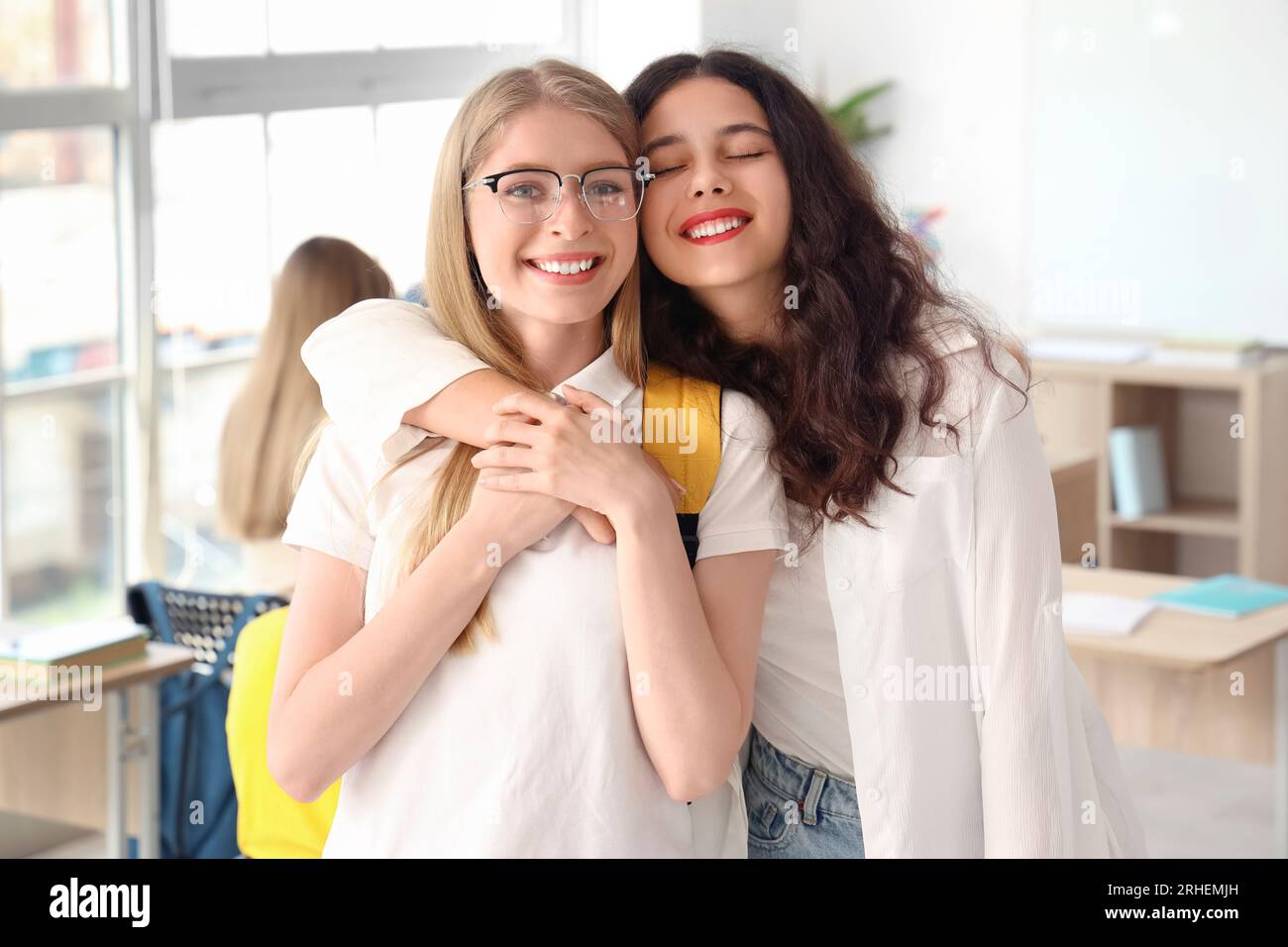 Female students hugging in classroom Stock Photo - Alamy