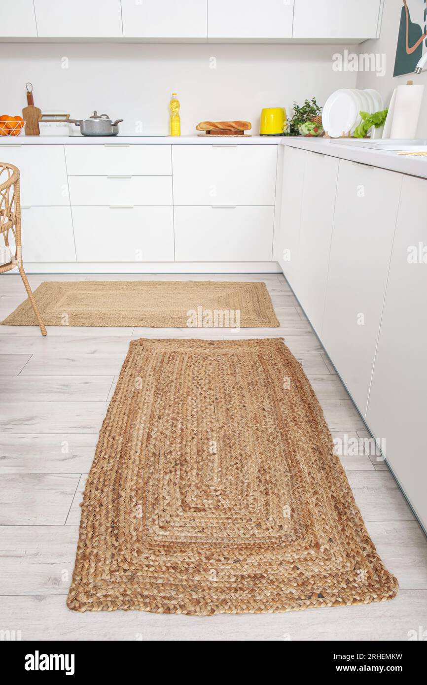 Stylish wicker rugs in interior of modern kitchen Stock Photo - Alamy