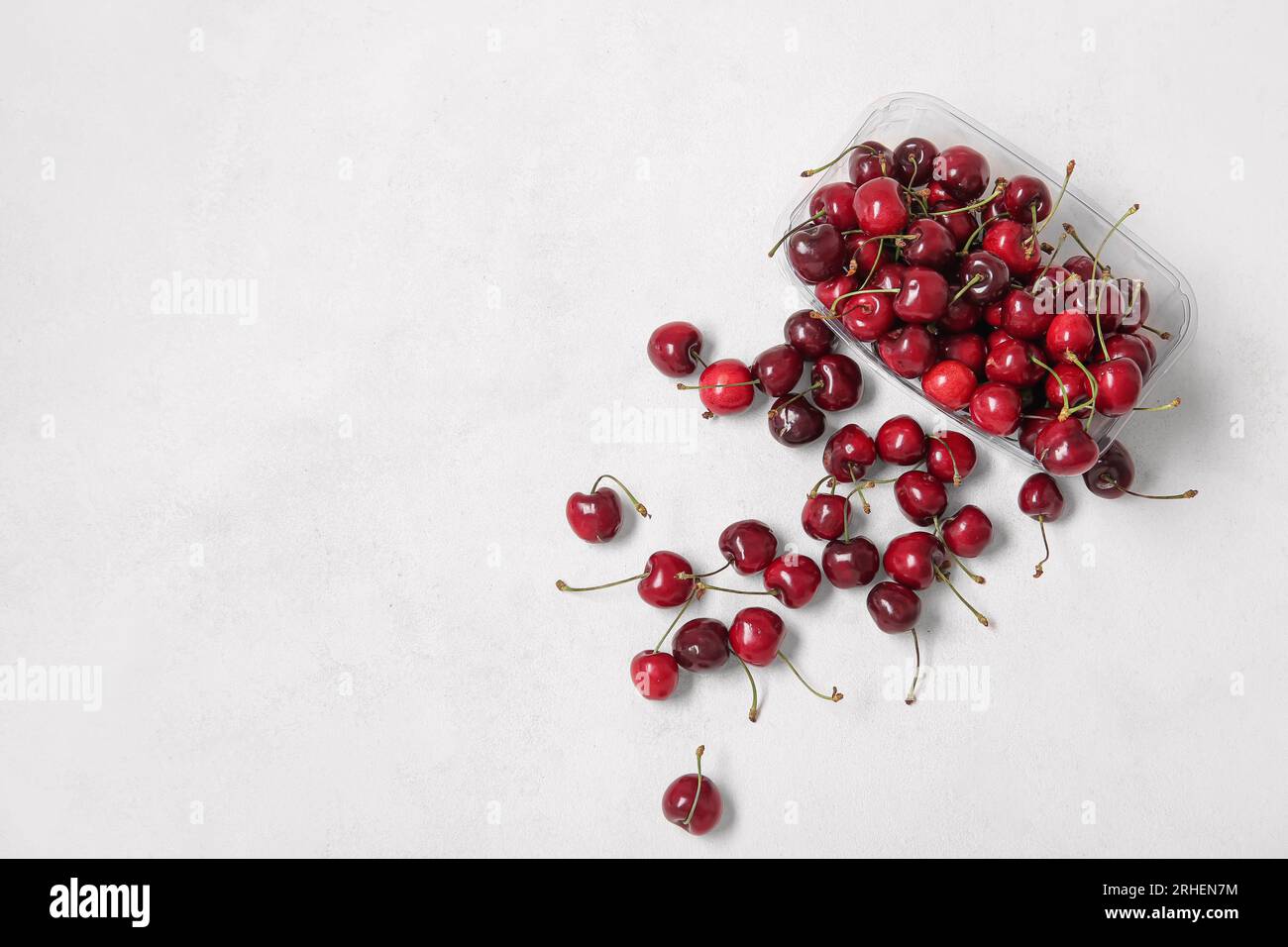 Plastic container with fresh cherry on light background Stock Photo - Alamy