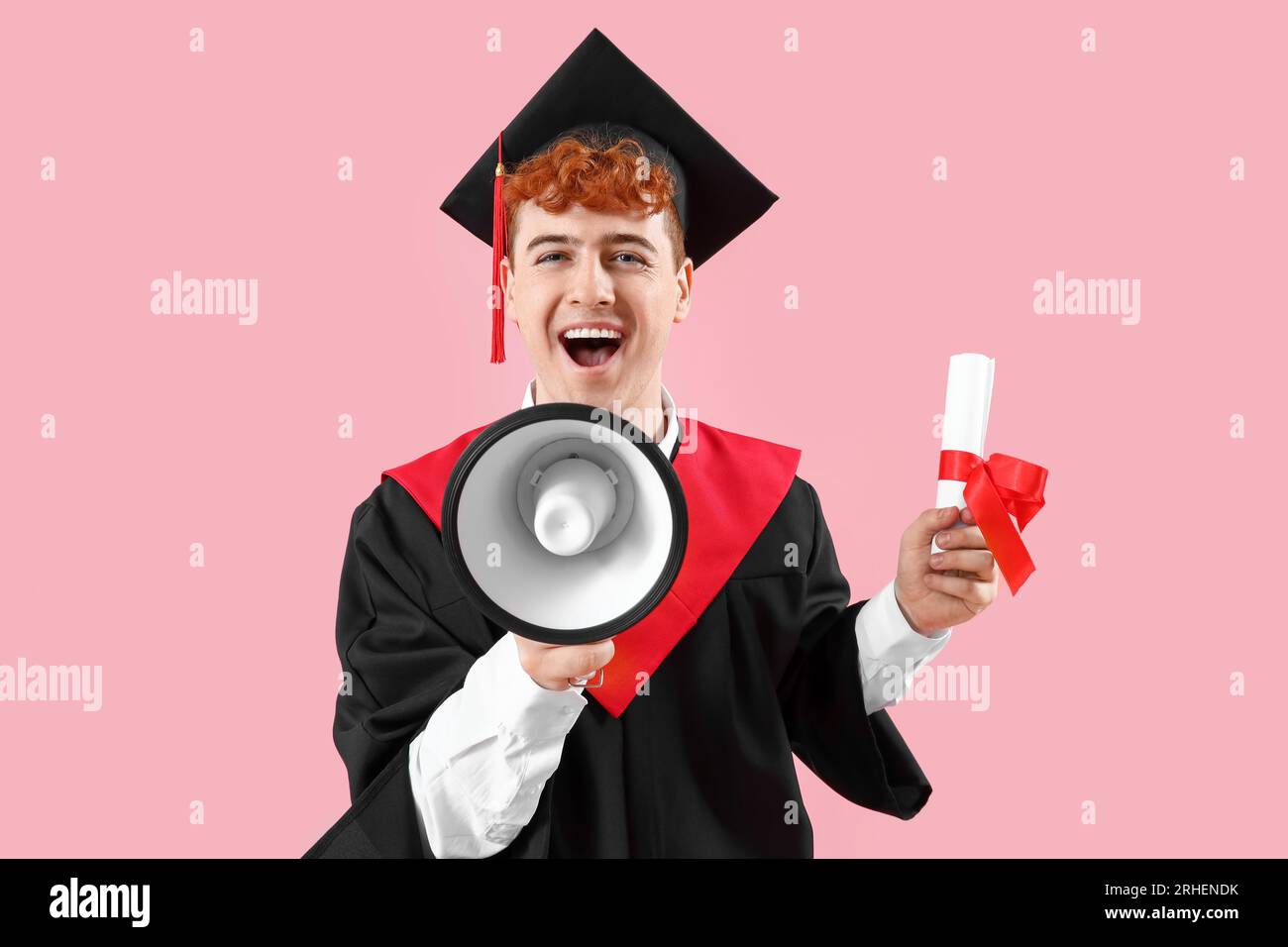 Male graduate student with diploma shouting into megaphone on pink ...