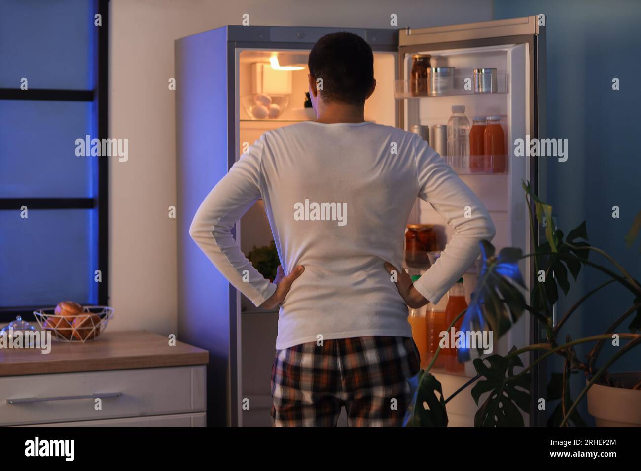 Hungry young man near open fridge in kitchen at night, back view Stock ...