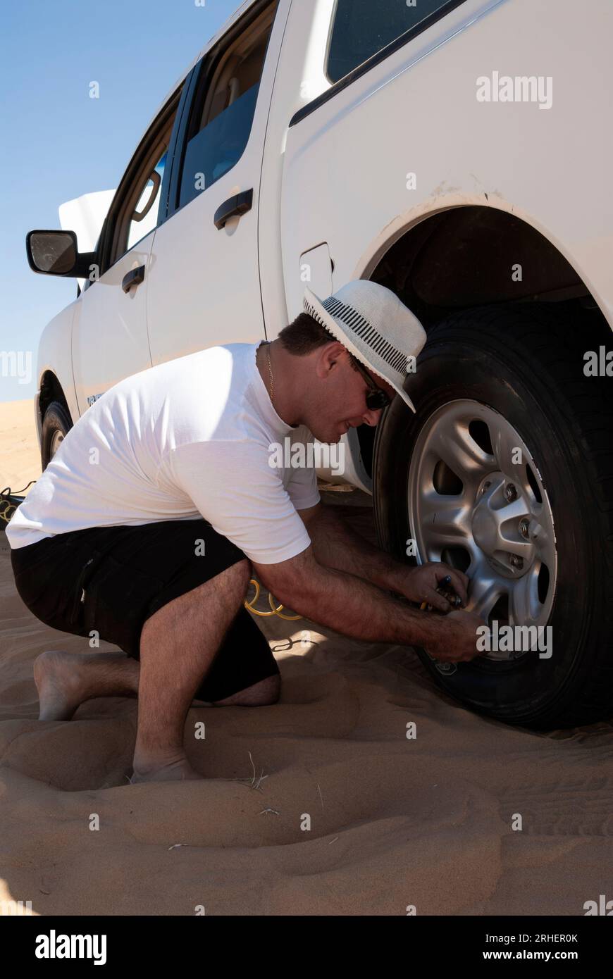 Vertical view of a man inflating the tyres of his 4x4 off-road truck in ...