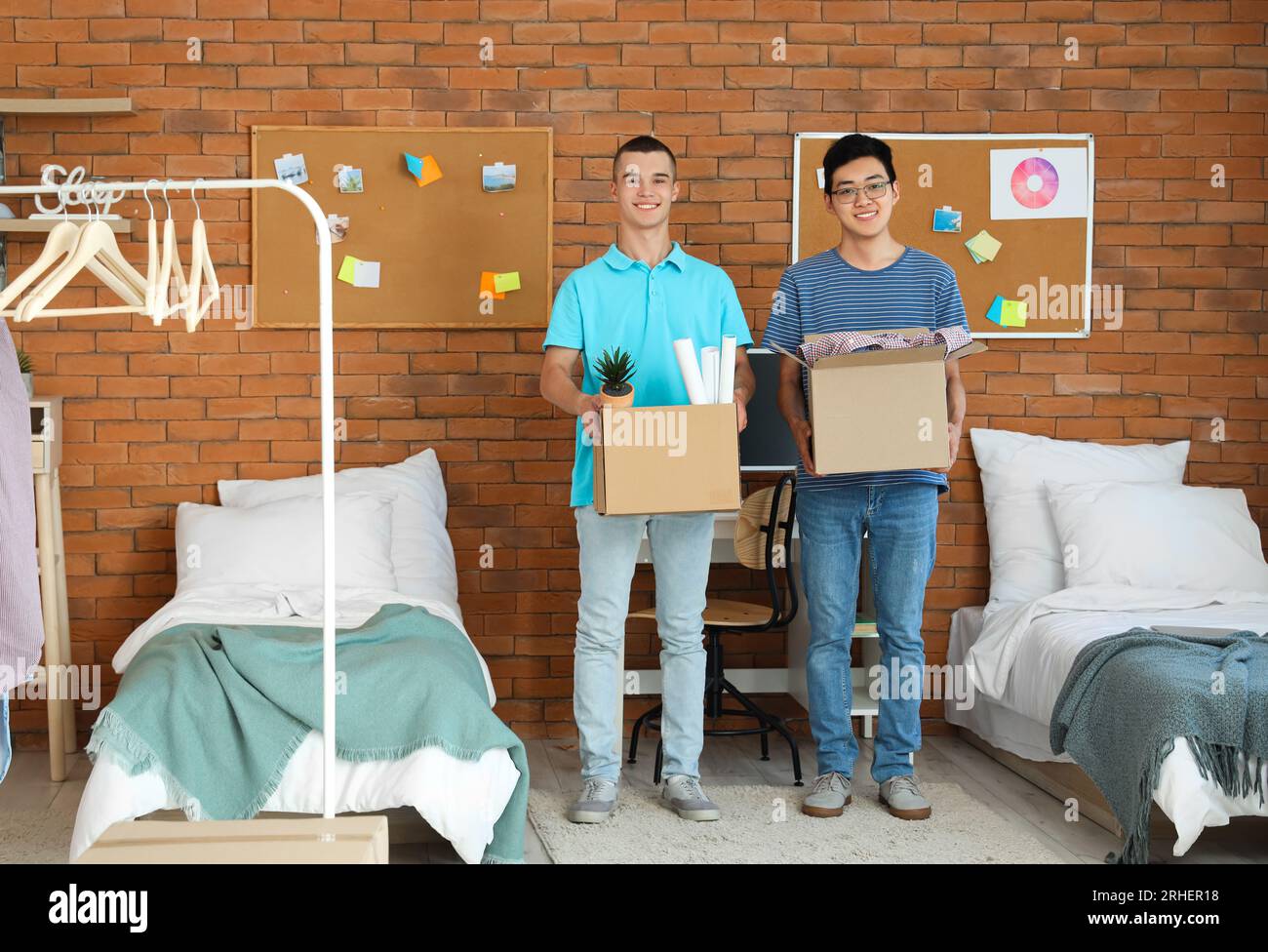 Male students with boxes in dorm room on moving day Stock Photo - Alamy