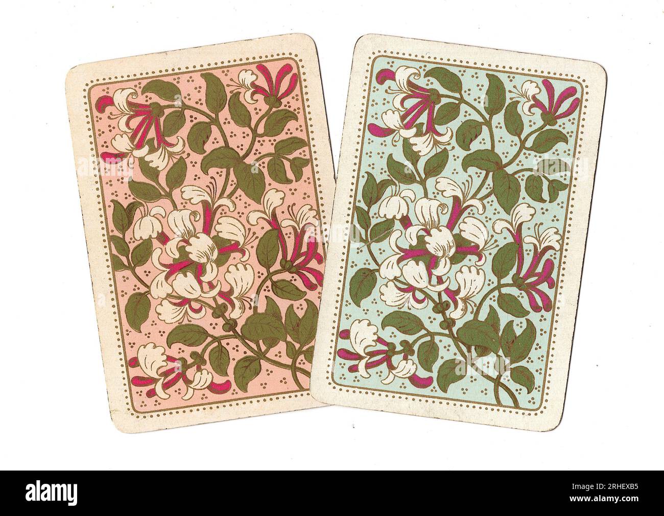 A pair of antique playing cards showing the reverse on a white ...