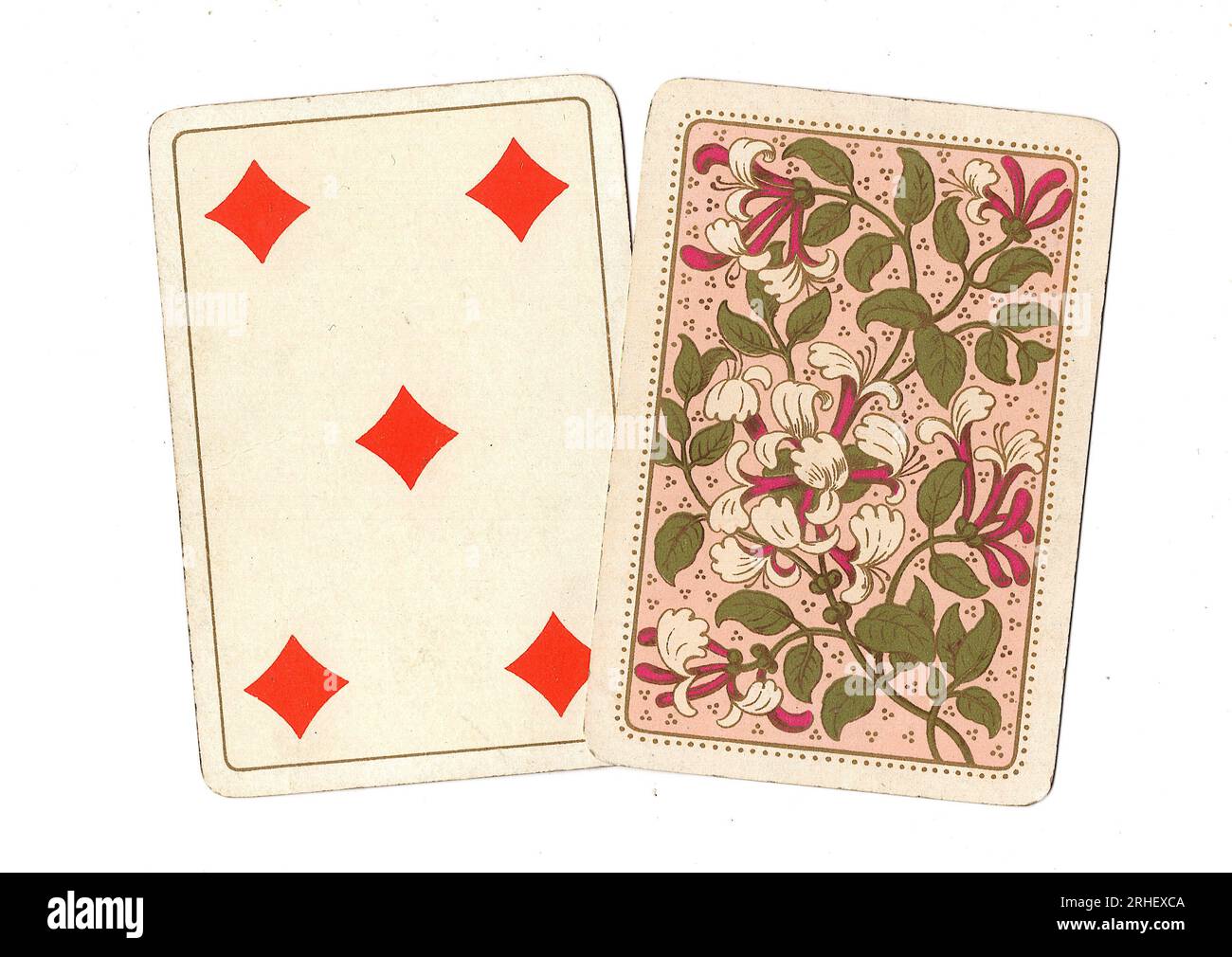 A pair of antique playing cards with the five of diamonds revealed on a ...