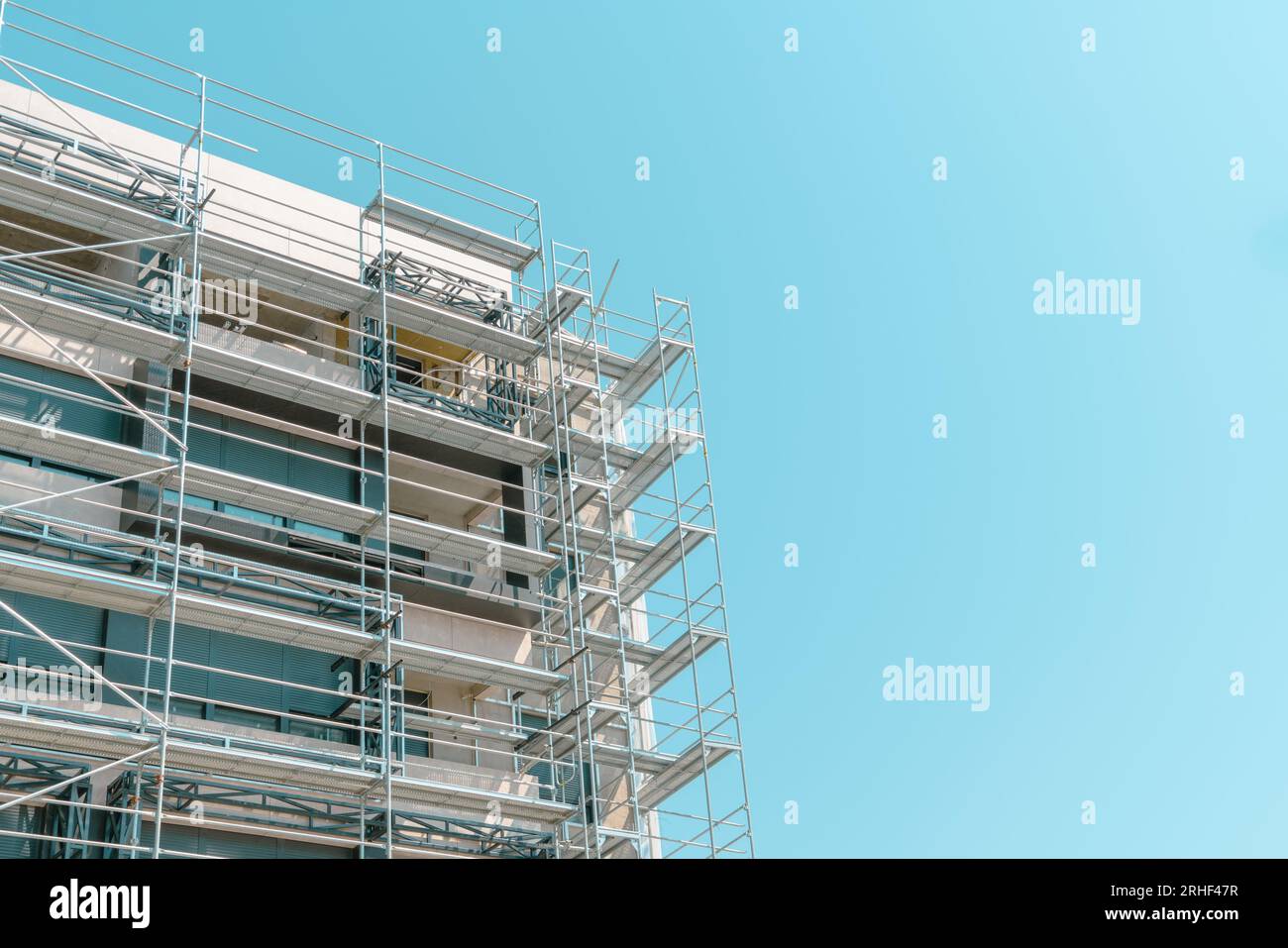 construction site, facade and scaffolding on background of blue sky ...